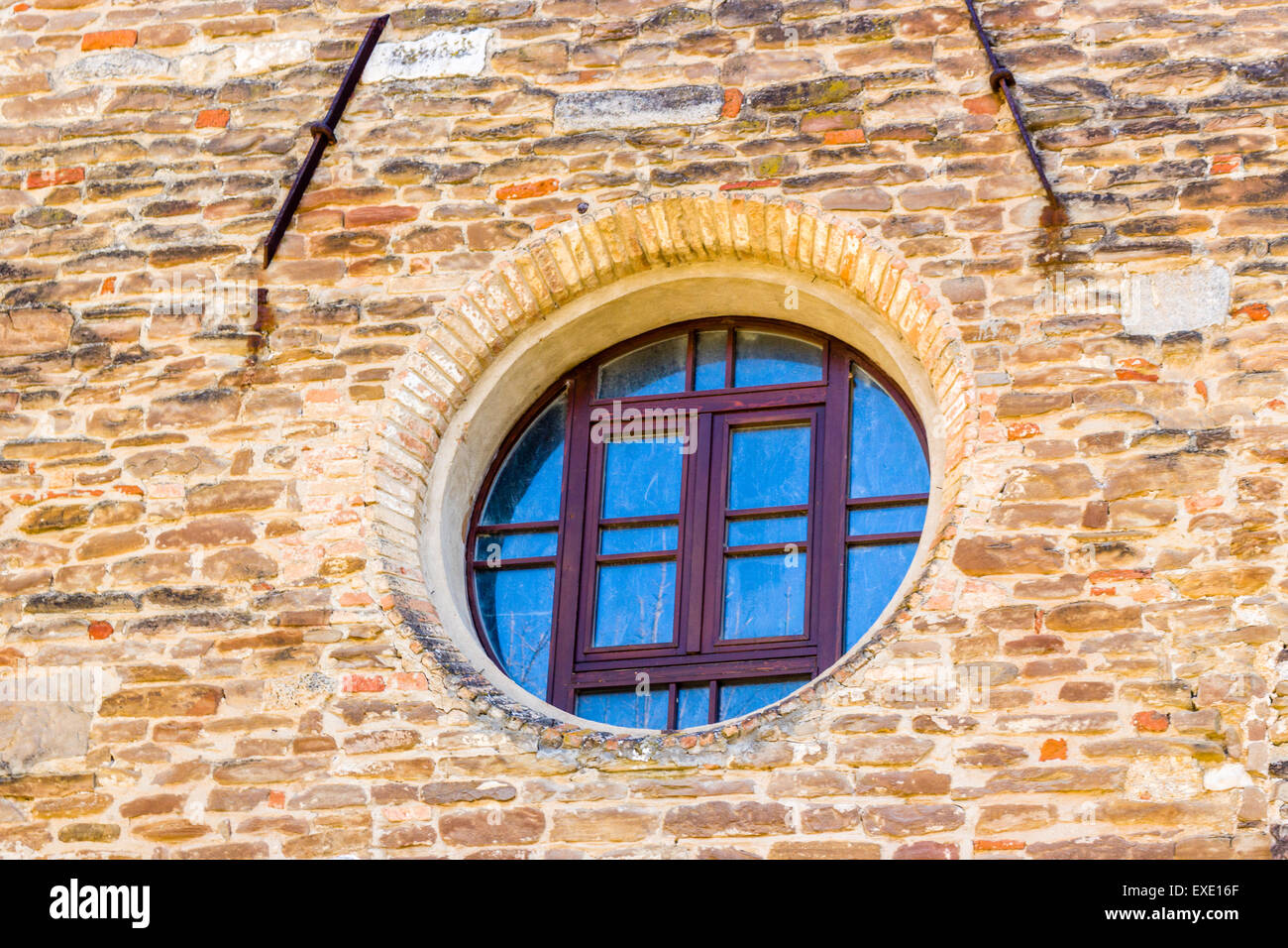 Round window on ancient brick wall of Catholic church in Italian ...