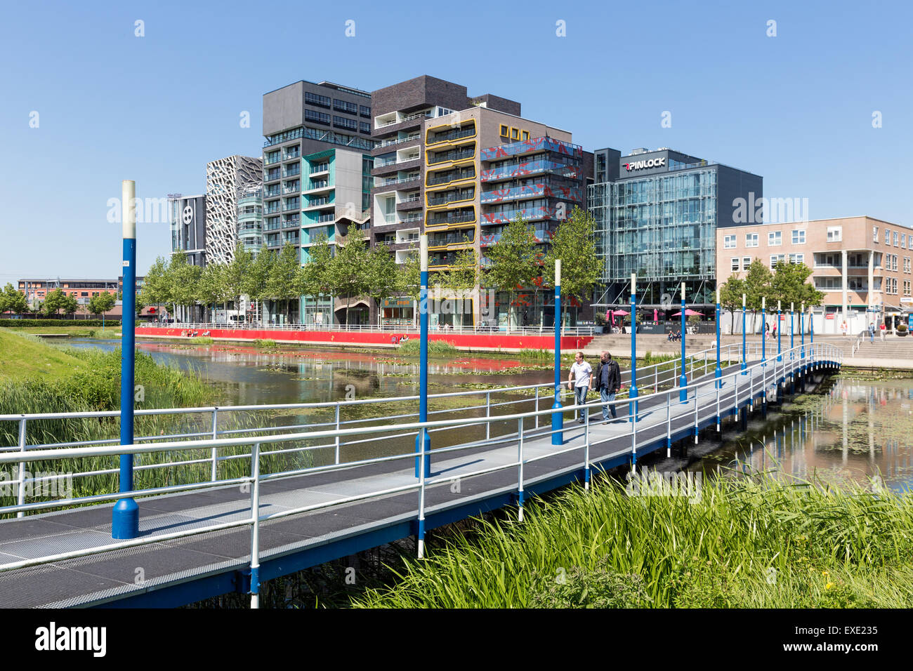 View at modern apartments and office buildings with catwalk crossing a ...