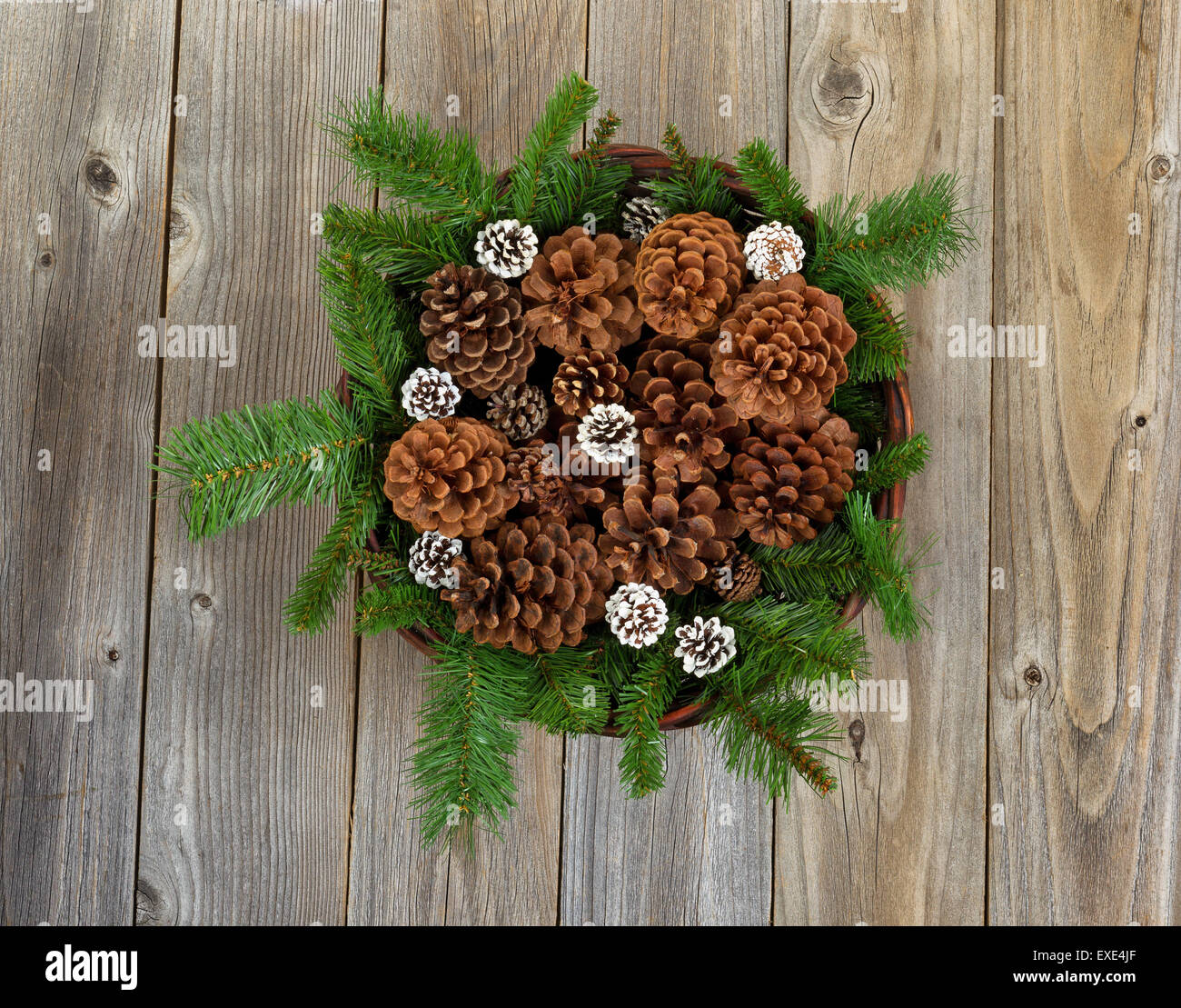Top view of a Christmas basket filled with pine tree branches, cones on ...