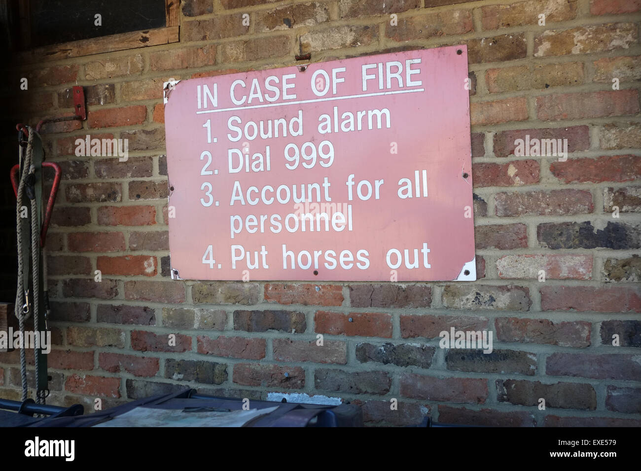 Old well worn fire warning sign in a brick wall of a stable, July 2015 ...