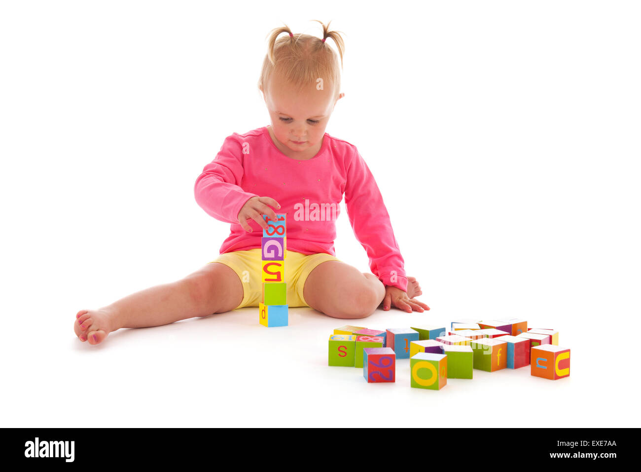 Portrait toddler girl playing with blocks isolated over white ...