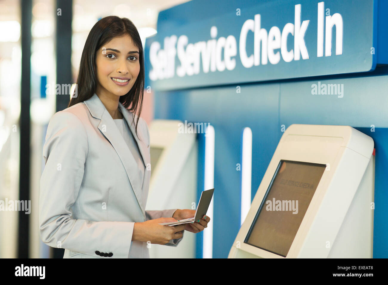 gorgeous Indian businesswoman using self help check in machine at ...