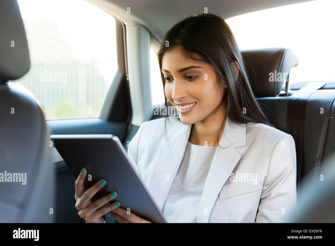 happy Indian businesswoman using tablet computer inside a car Stock ...