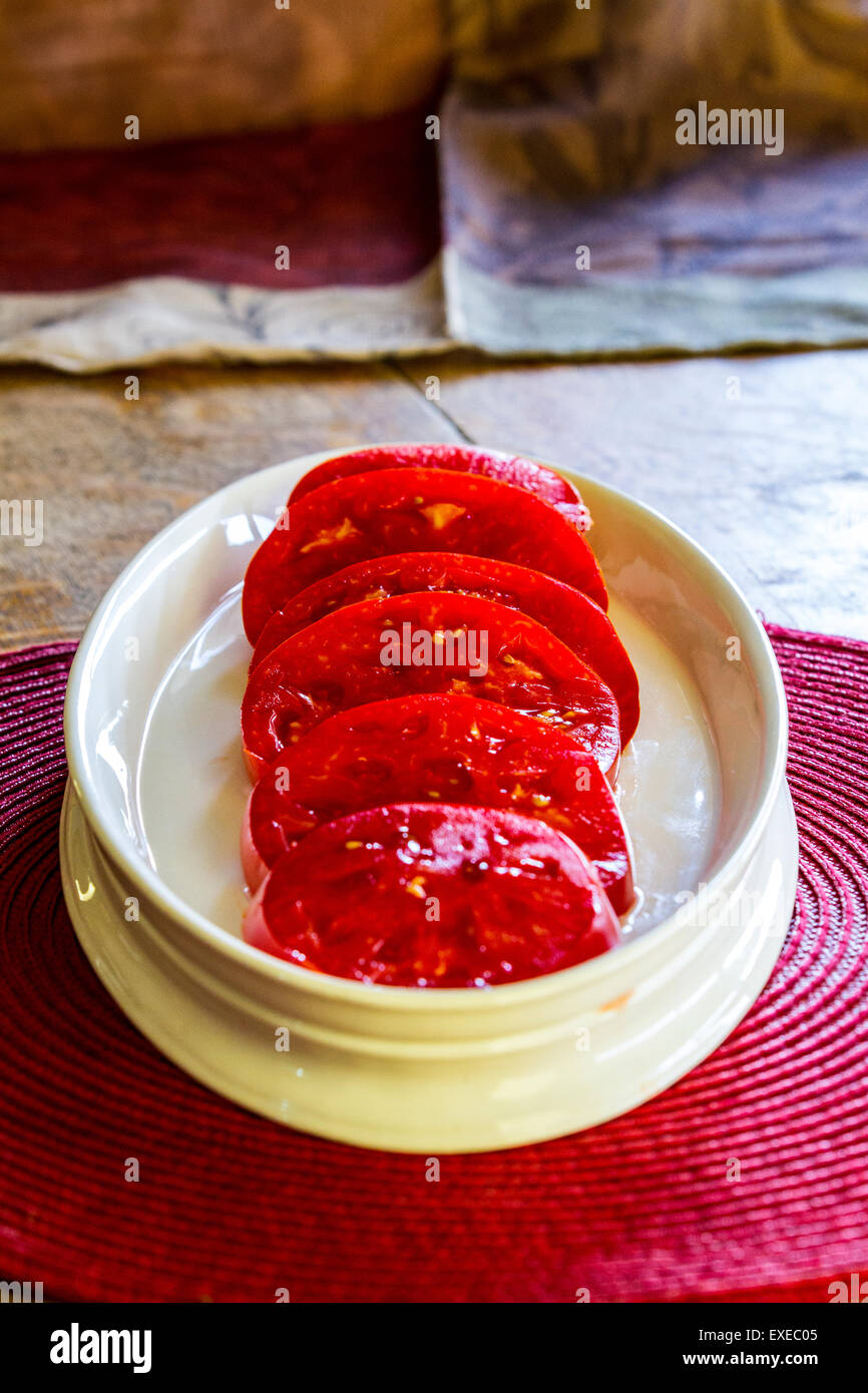 A Burpee Ace 55 Home Grown Heirloom Tomato sliced on a ceramic tray ...