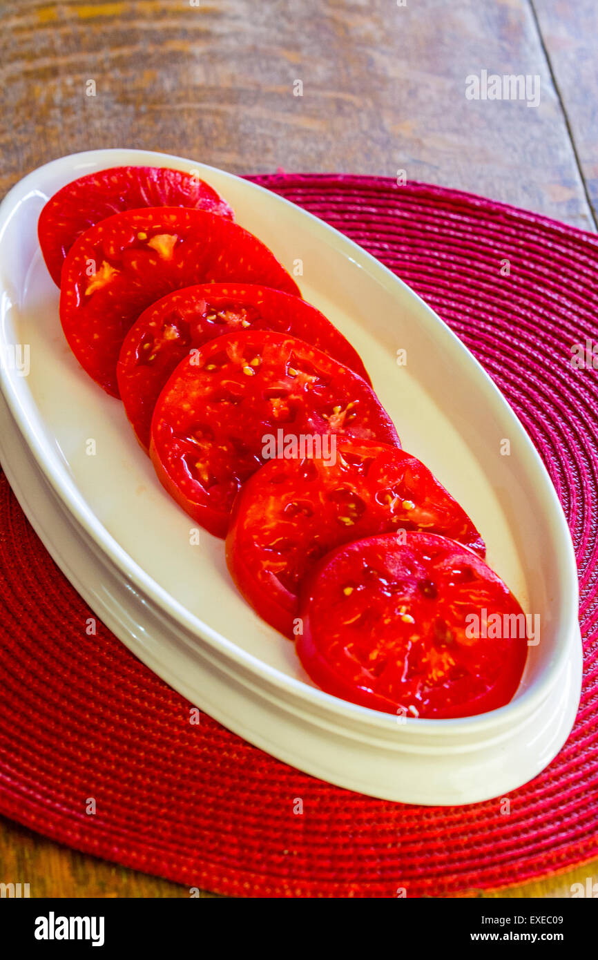 A Burpee Ace 55 Home Grown Heirloom Tomato sliced on a ceramic tray ...