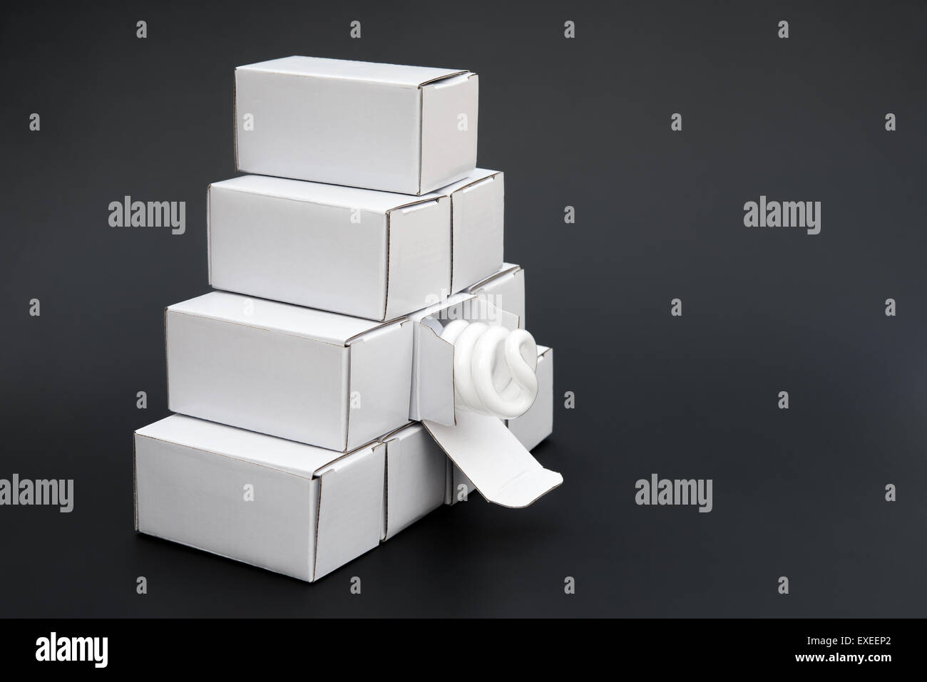 stack of boxes with one open, an energy saving light bulb stands out ...