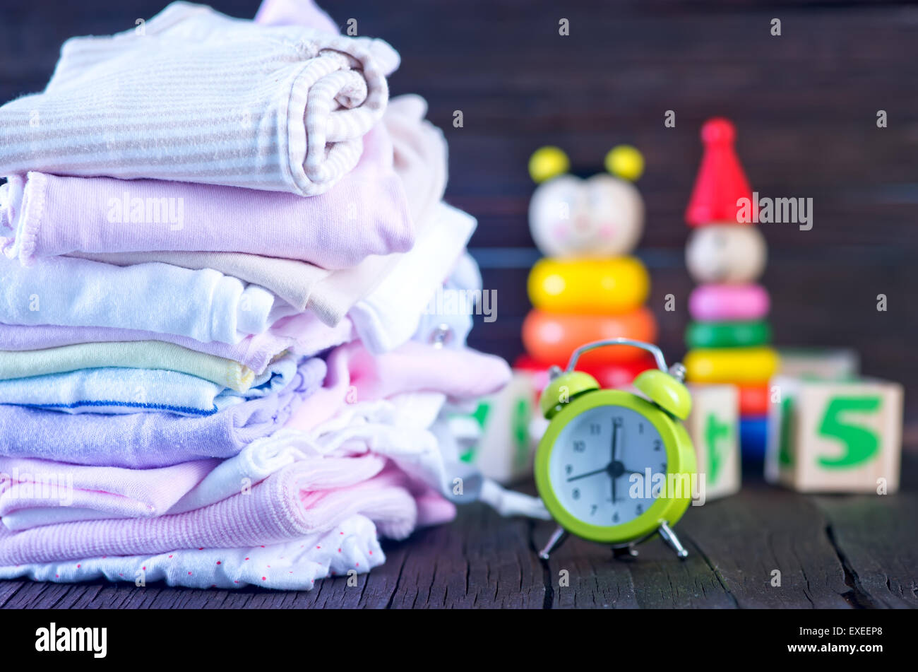 baby clothes and toys on a table Stock Photo - Alamy