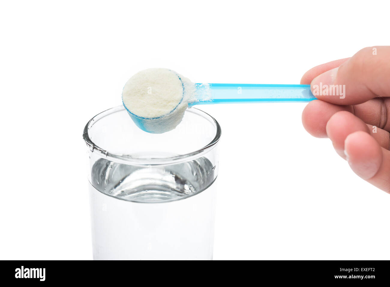 putting powdered milk into a glass cup with clipping path close up ...