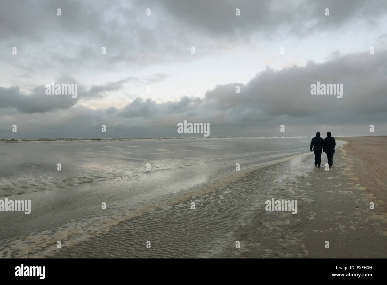 Walkers in bad weather on the beach of the North Sea island Langeoog ...