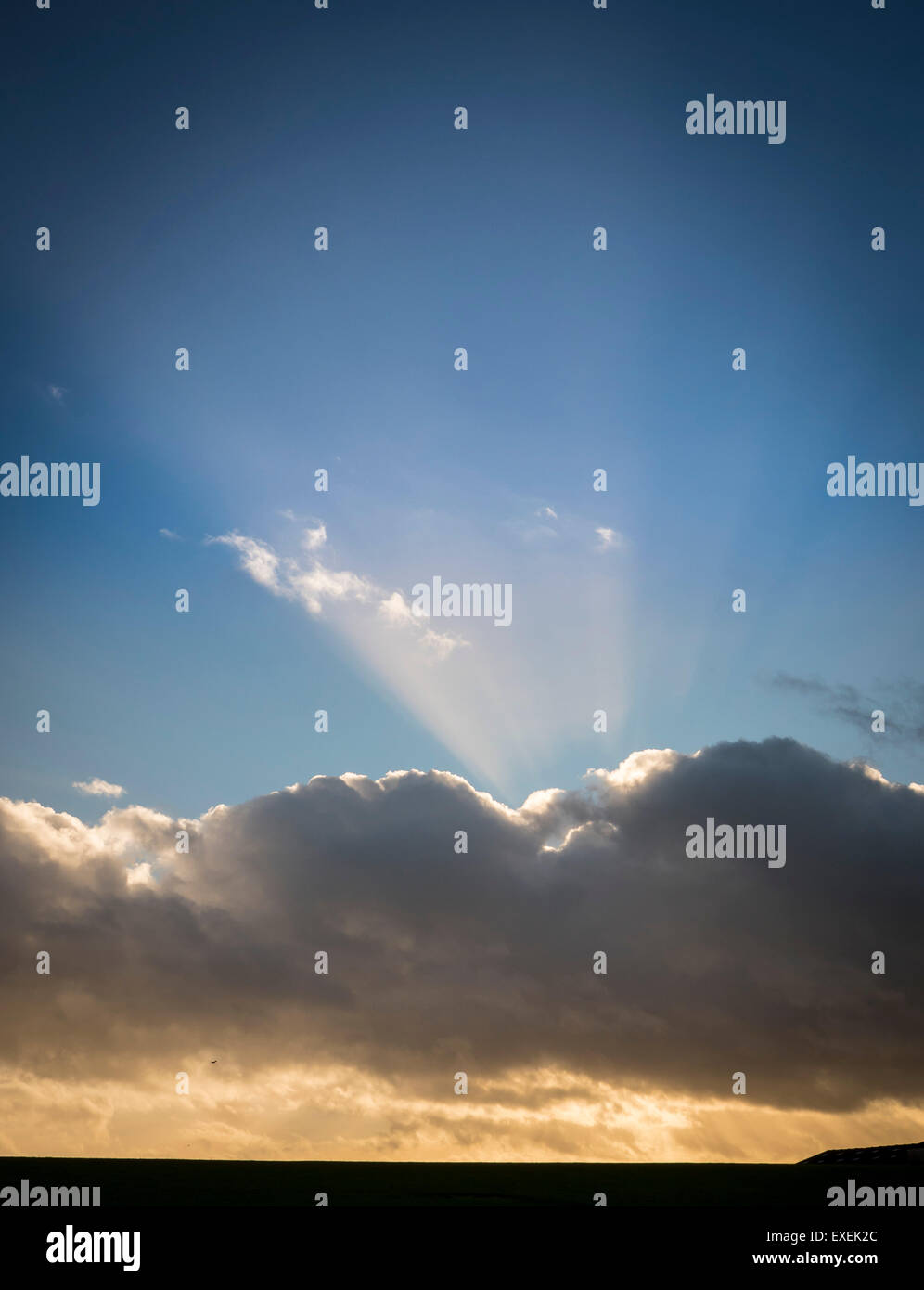 Shafts of sun light above a cloud near sunset Stock Photo - Alamy