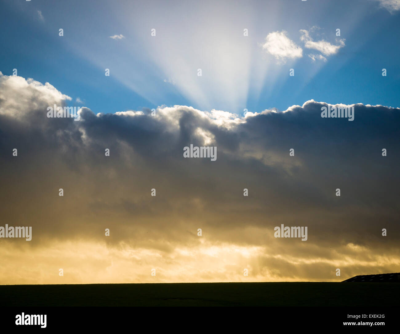 Shafts of sun light above a cloud near sunset Stock Photo - Alamy