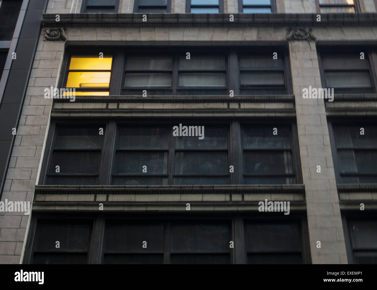 A single lit window in an otherwise totally dark building in Manhattan ...