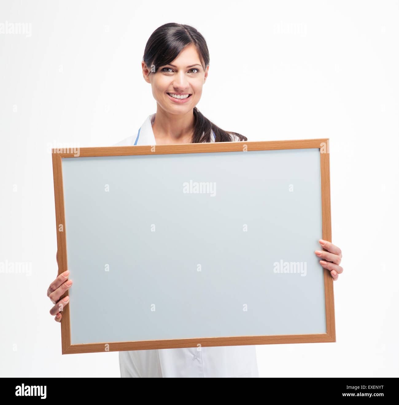 Smiling young female doctor holding blank white board isolated on a ...