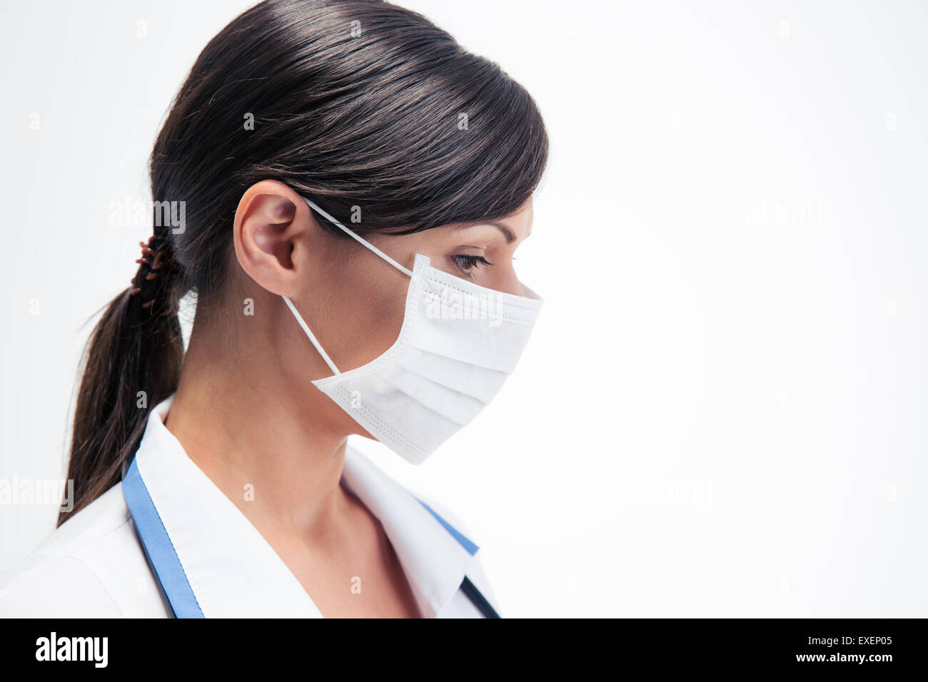 Side view portrait of a pensive female medical doctor in mask isolated ...