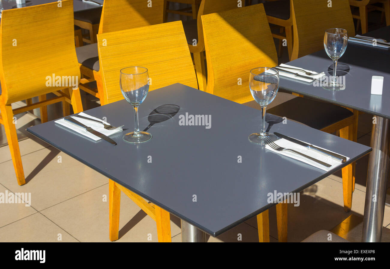 restaurant tables with silverware and glasses ready for a lunch or ...