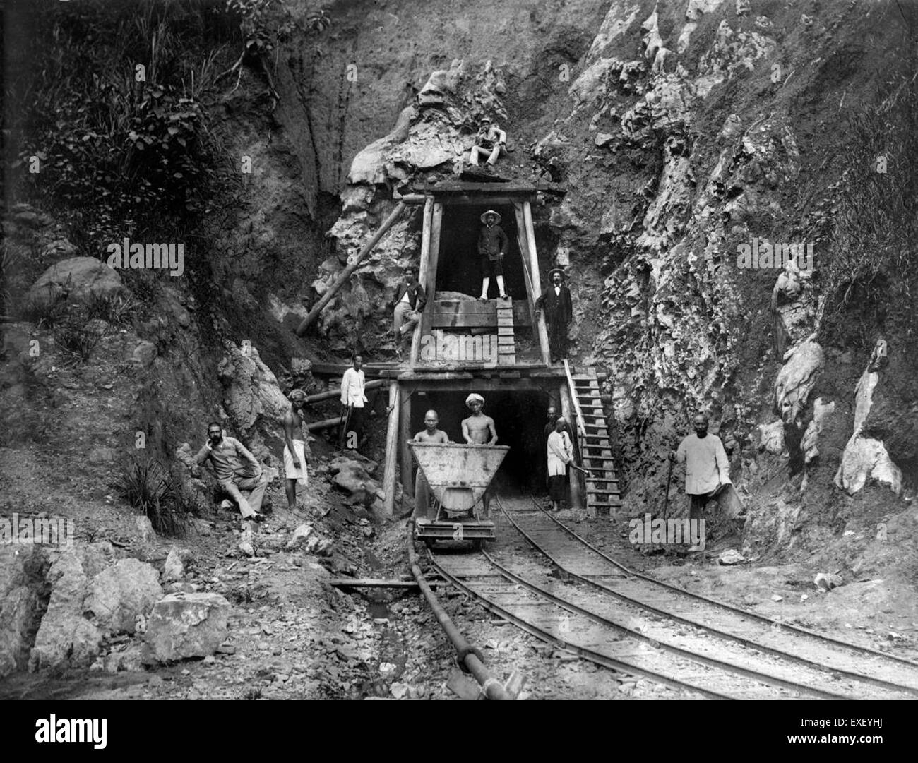 This historic image shows miners at the entrance of a mine ...