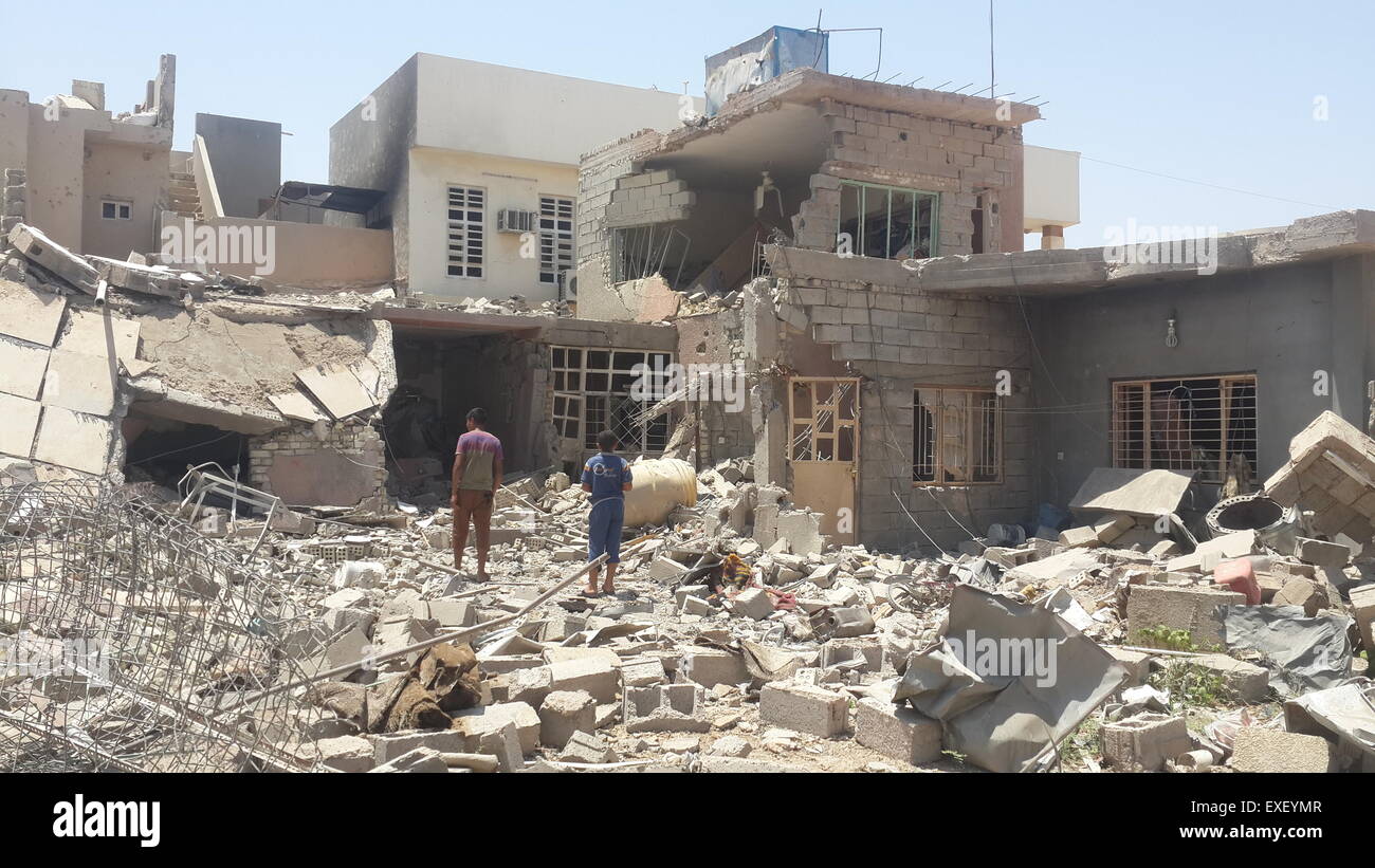 Fallujah, Iraq. 13th July, 2015. Two boy stands in front of a destroyed ...