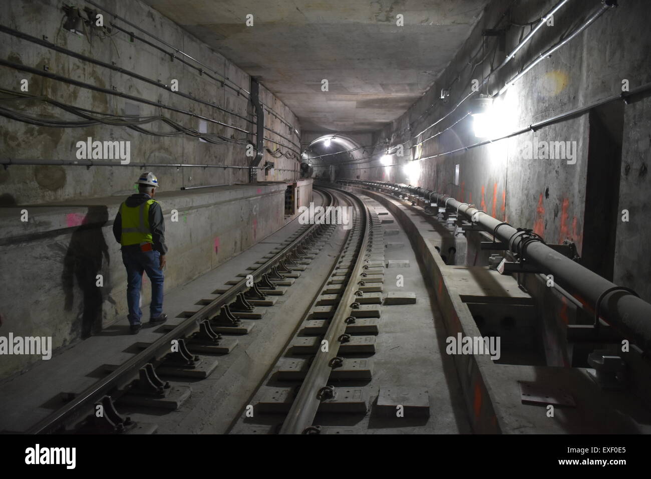 Construction workers walk through the new underground line tunnel at ...