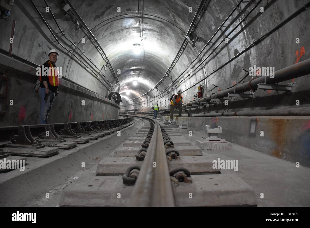 Construction workers walk through the new underground line tunnel at ...