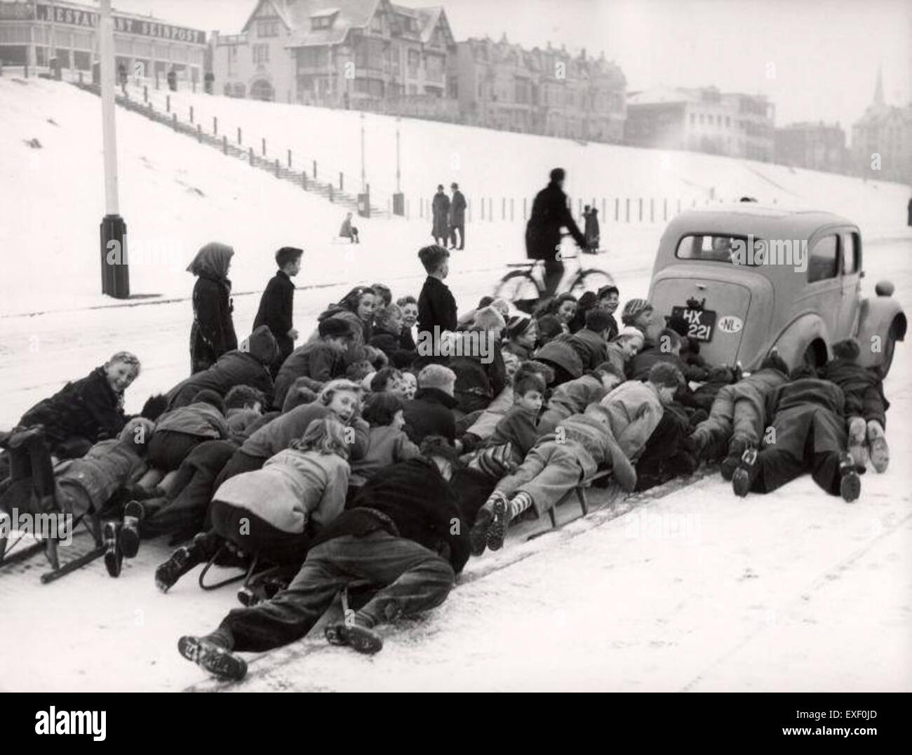 This historical image captures children being pulled on sledges by a ...