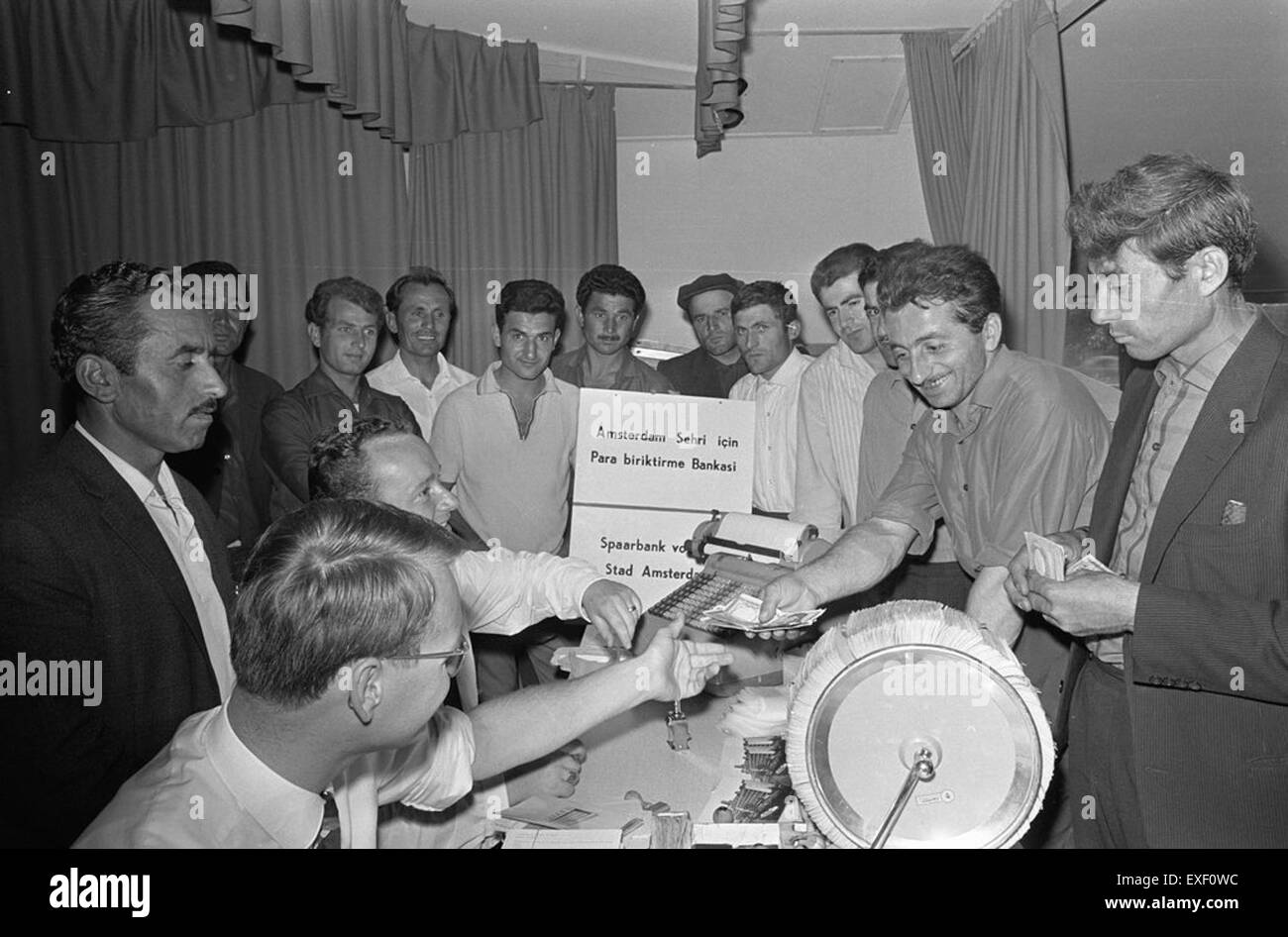 This photograph captures Turkish guest workers saving money while ...