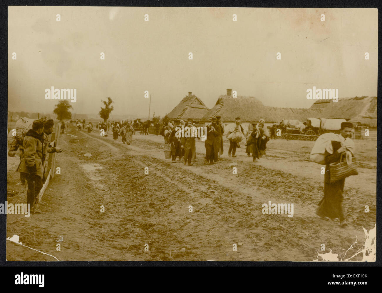 A historic photograph depicting fleeing civilians on a rural road. This ...