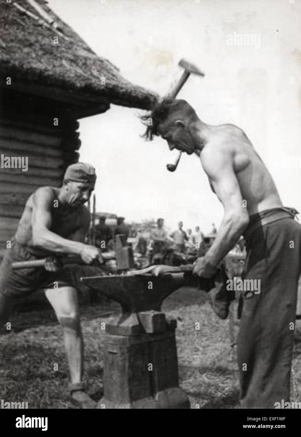 This historical photograph, titled 'Duitsers bij aambeeld' (Germans at ...