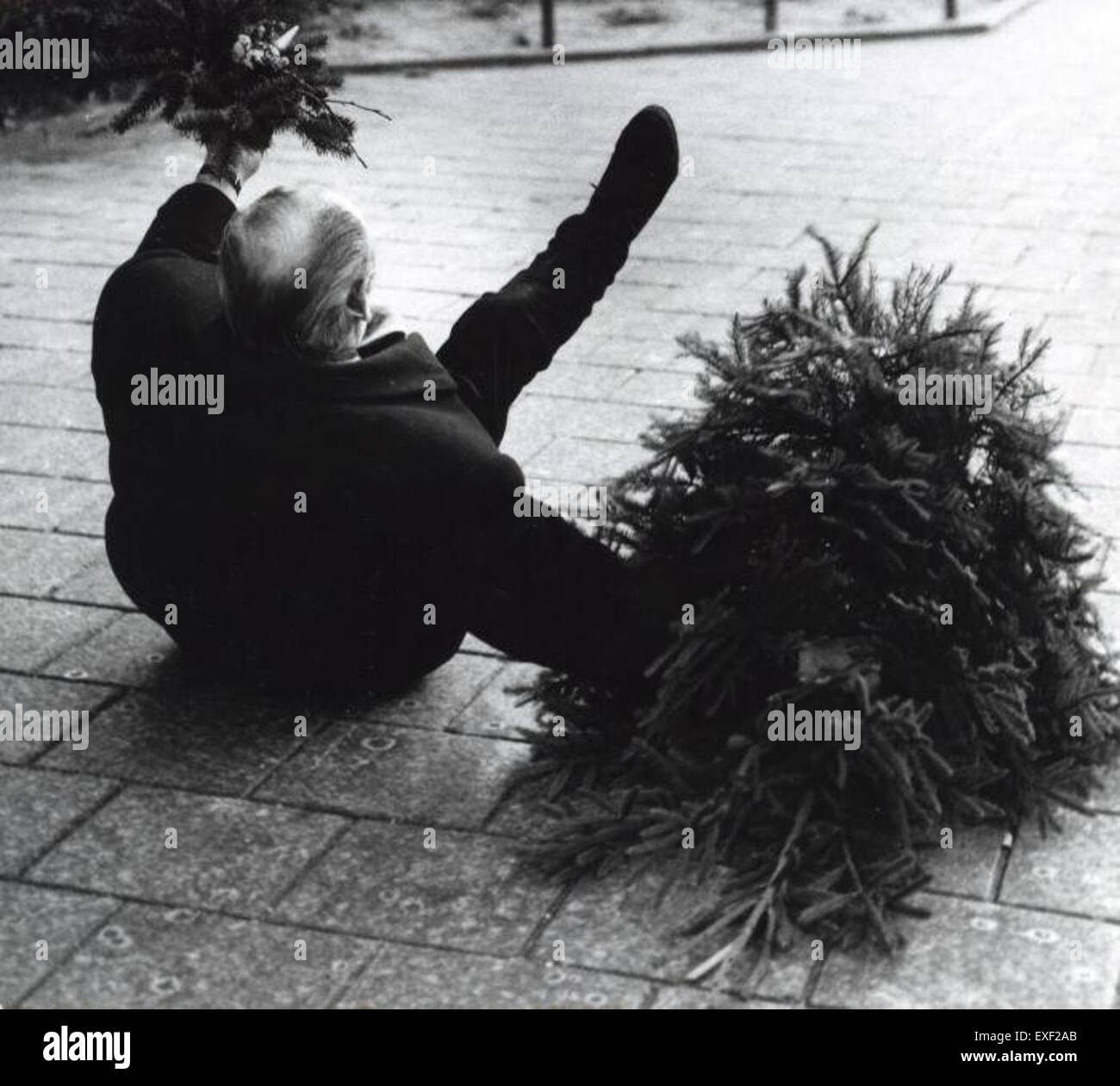 This image shows a man falling down with a Christmas decoration and ...