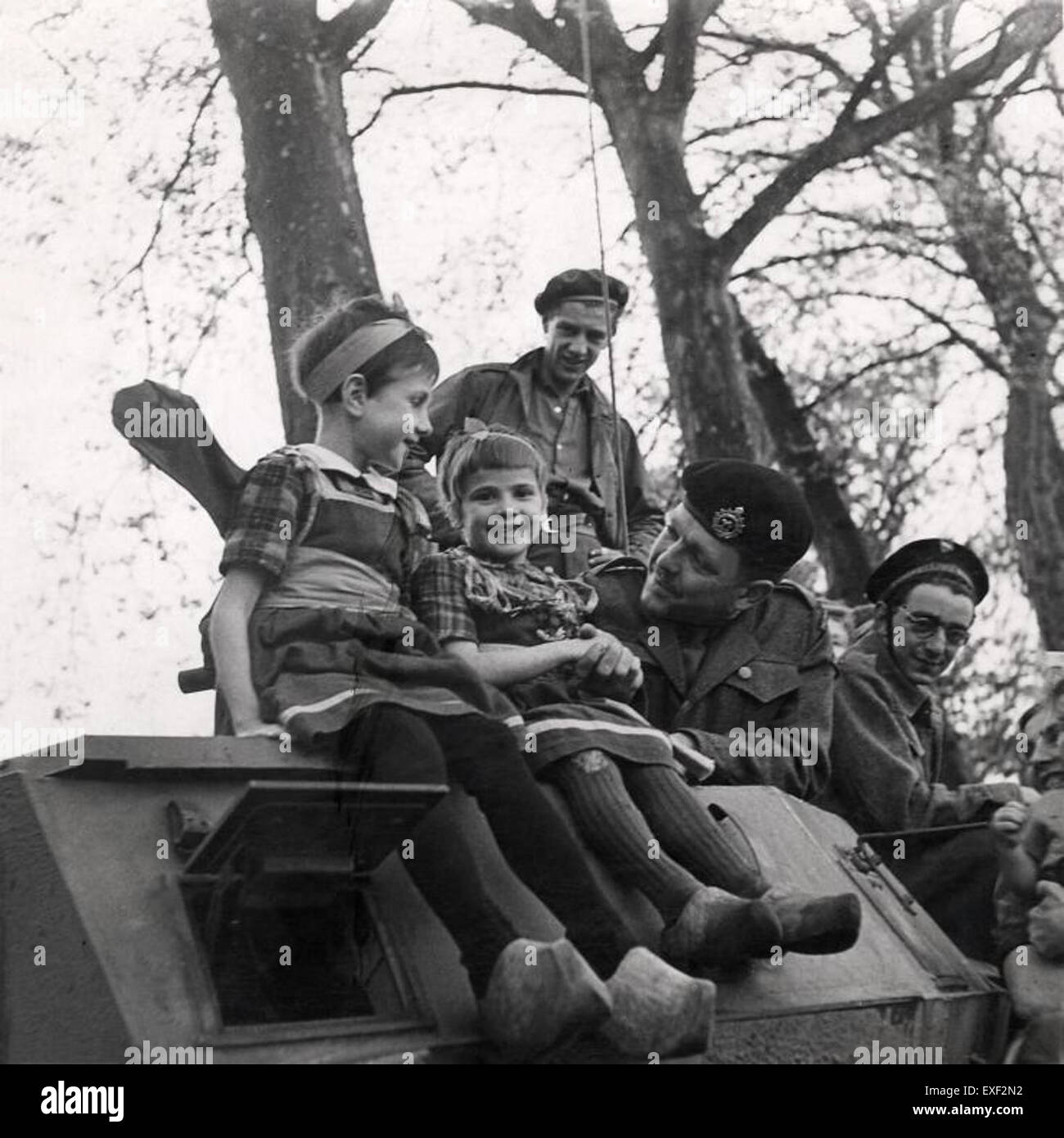 A photograph depicting children riding on a tank, reflecting the ...