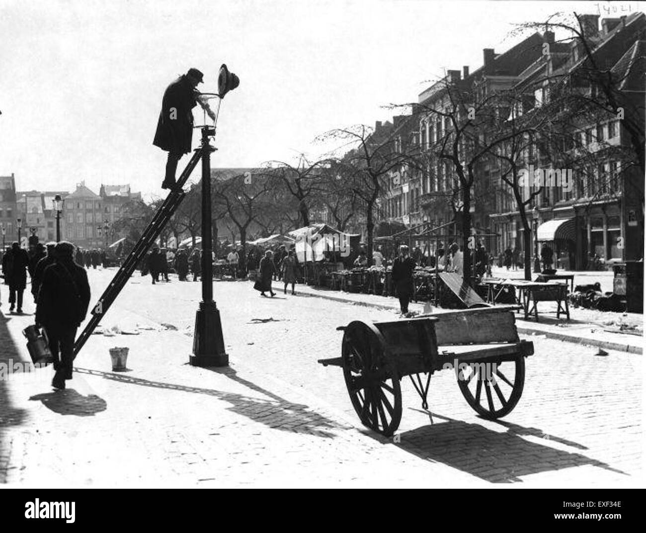 A traditional lamplighter depicted in action, lighting street lamps in ...