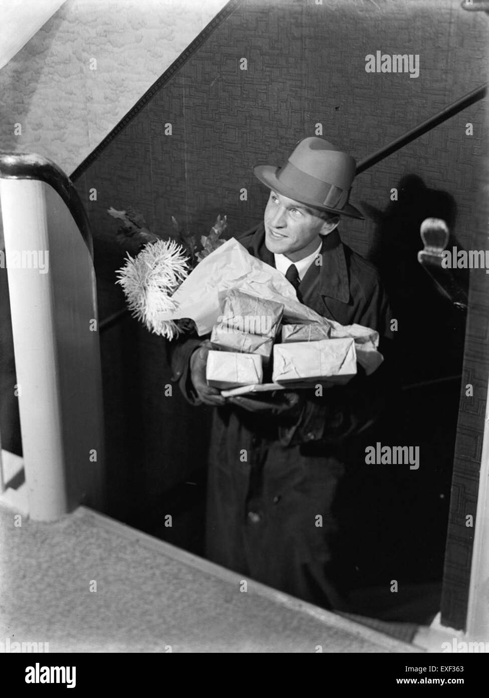 This image features a man carrying multiple wrapped gifts, symbolizing ...