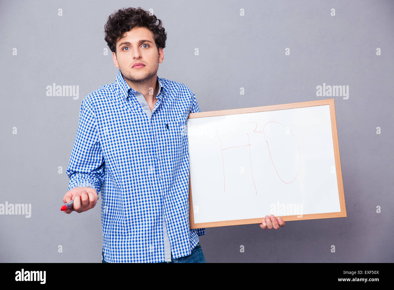 Young male student holding text board with marker and shrugging Stock ...