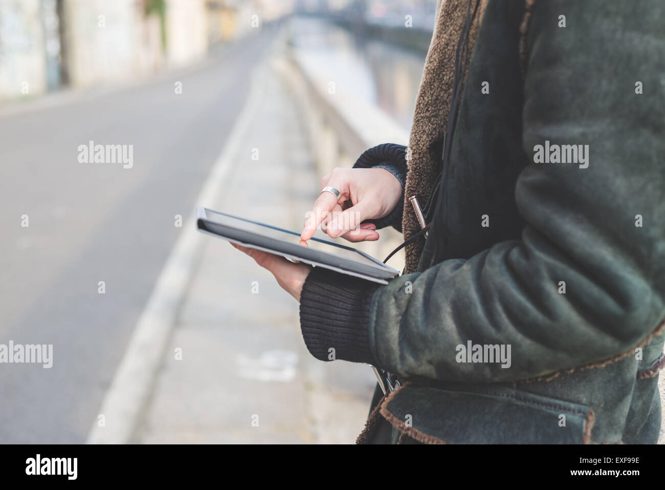 Man using digital tablet by canal, Milan, Italy Stock Photo - Alamy