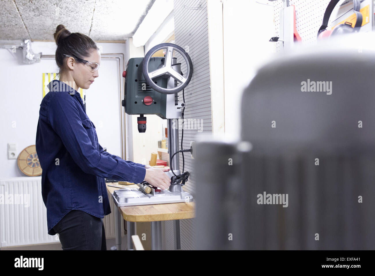 Young female carpenter drilling timber in workshop Stock Photo - Alamy