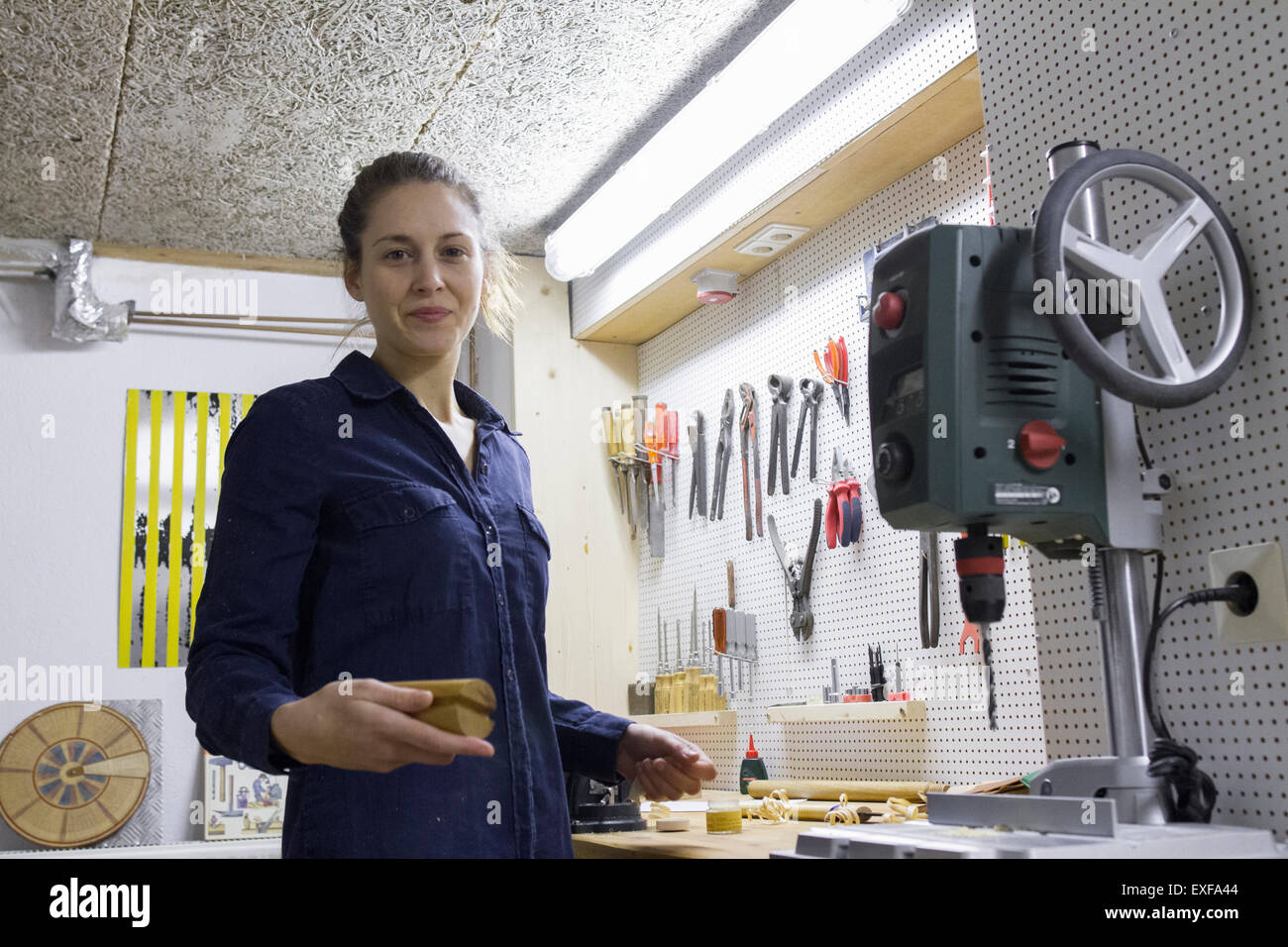 Portrait of young female carpenter at workbench in workshop Stock Photo ...