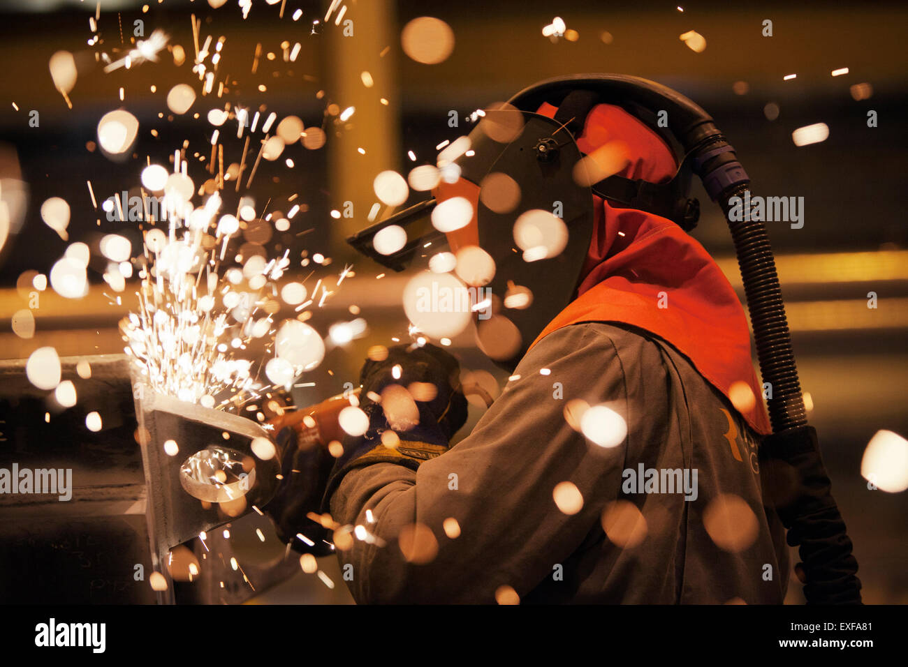 Sparks and worker using grinder Stock Photo - Alamy