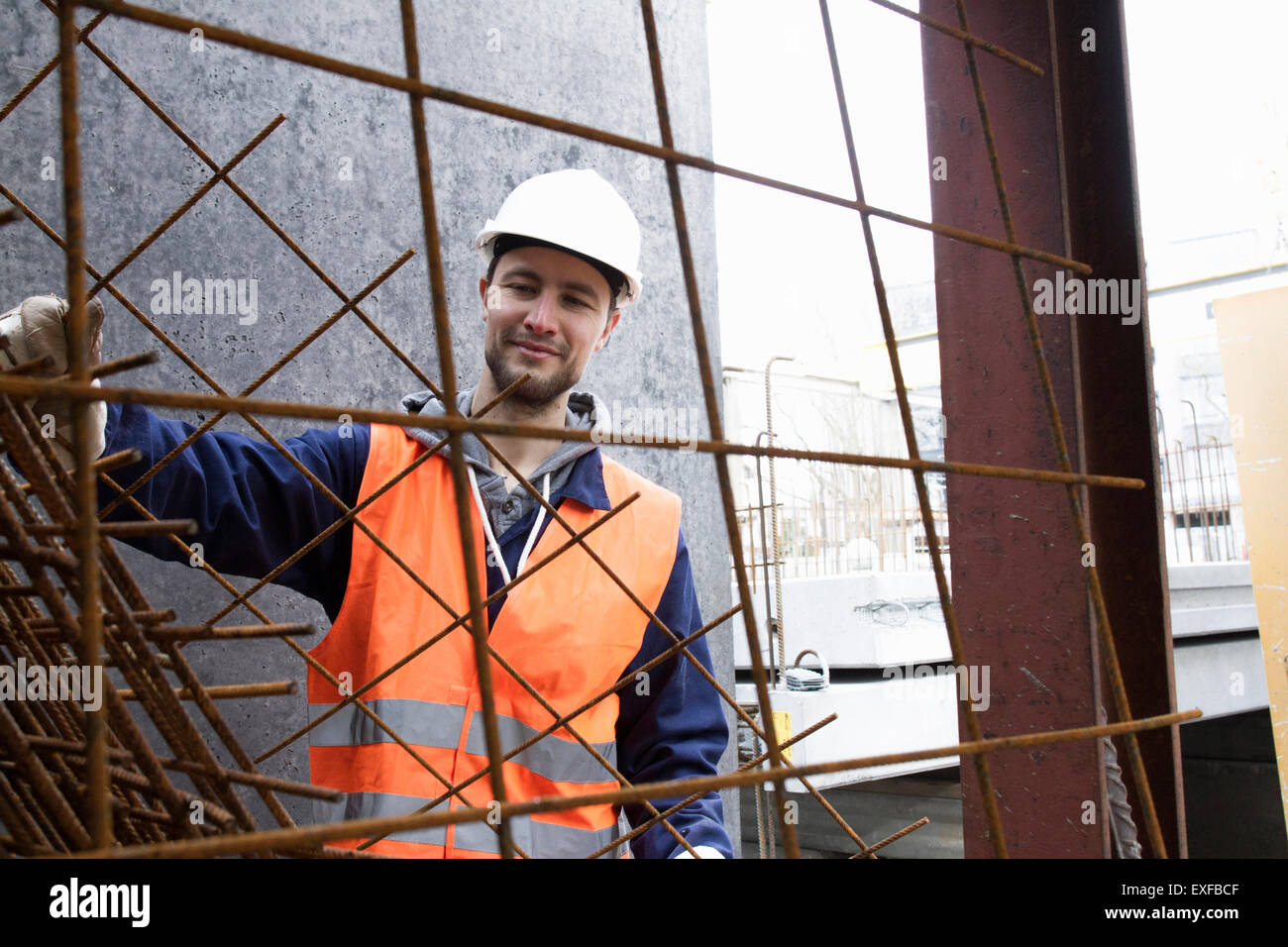Portrait of factory worker selecting steel mesh at concrete ...