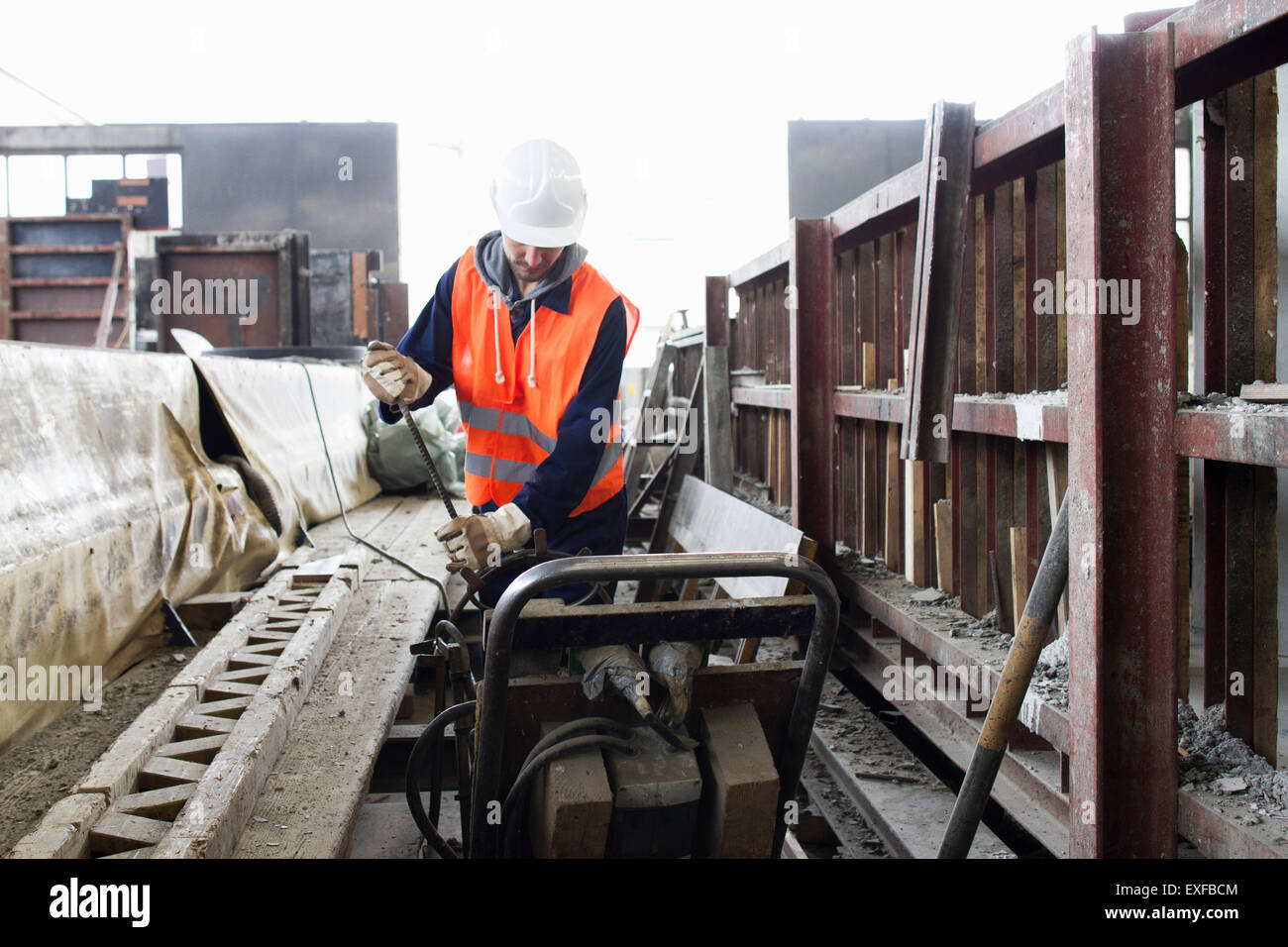 Factory worker selecting steel rod at concrete reinforcement factory ...