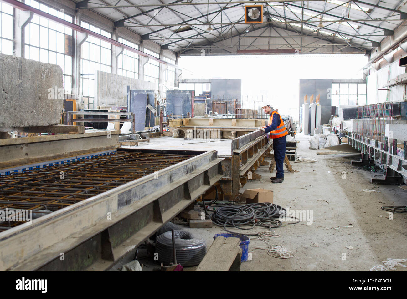 Factory worker on production line in concrete reinforcement factory ...
