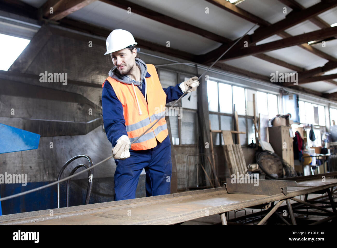 Factory worker moving steel rod at concrete reinforcement factory Stock ...
