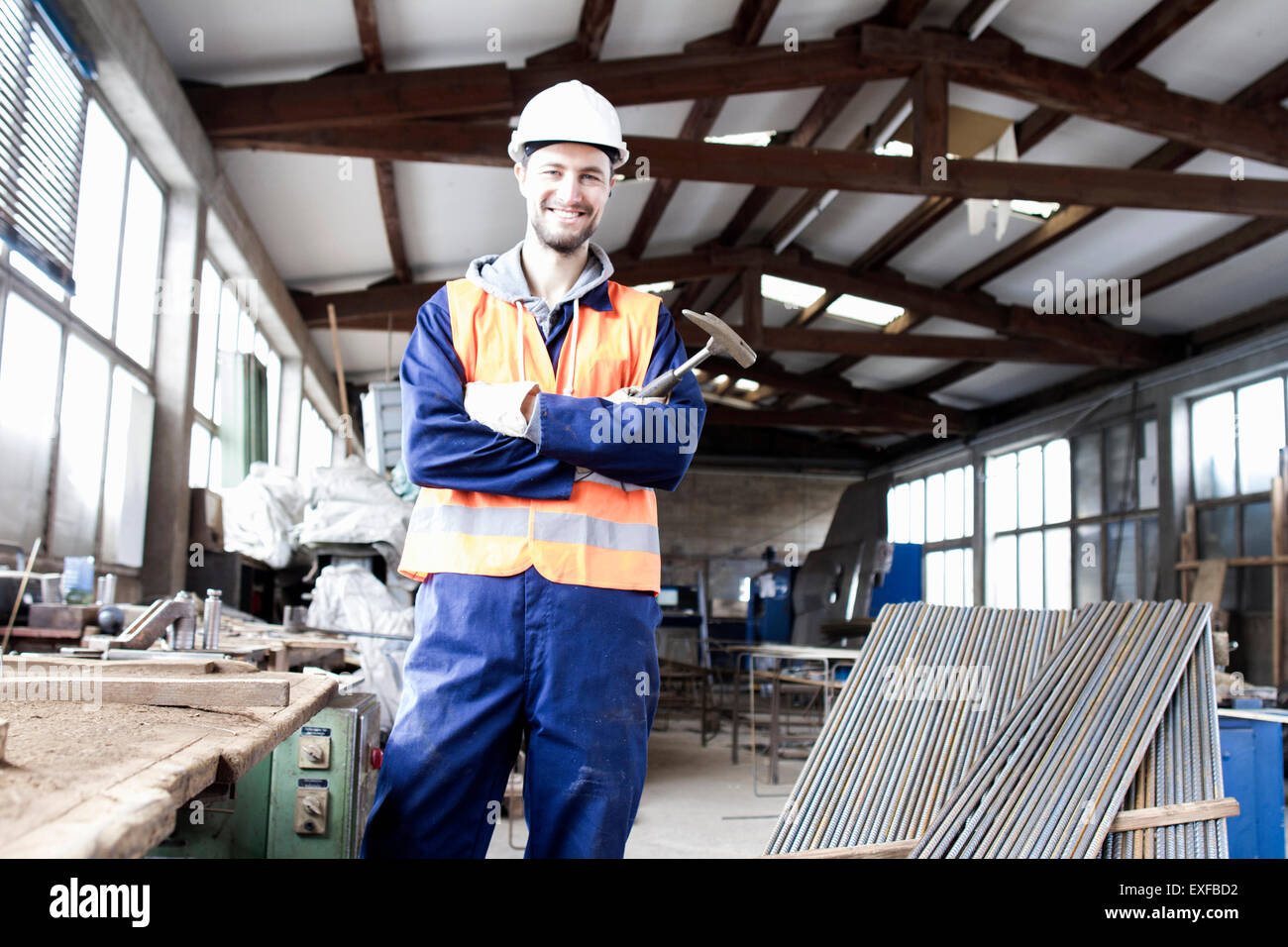 Portrait of factory worker with hammer in concrete reinforcement ...