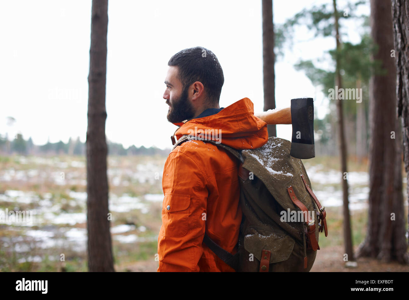 Young man carrying axe looking out from forest Stock Photo - Alamy