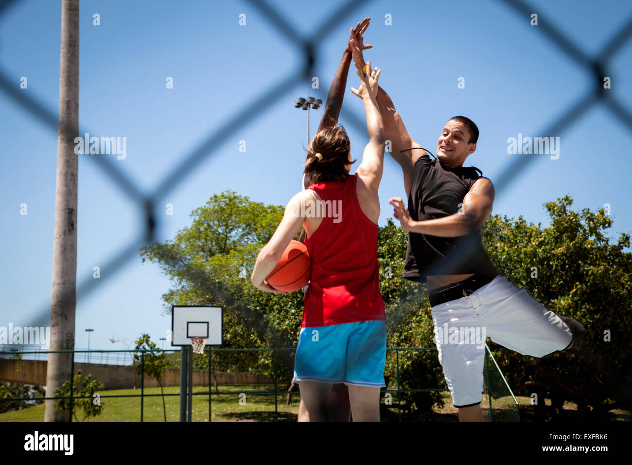 Male basketball team having high five on basketball court Stock Photo ...