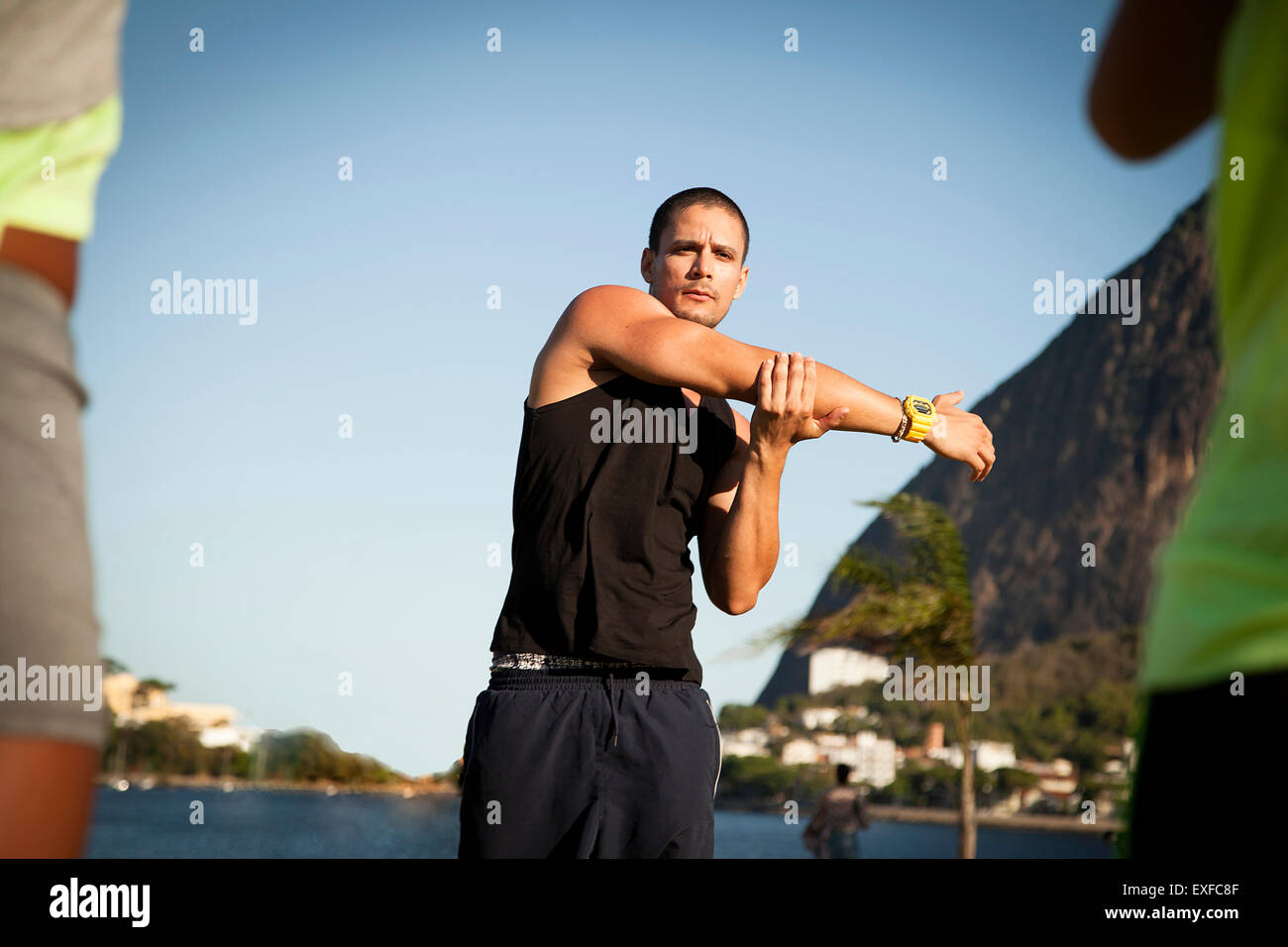 Personal trainer demonstrating stretch exercise in park Stock Photo - Alamy