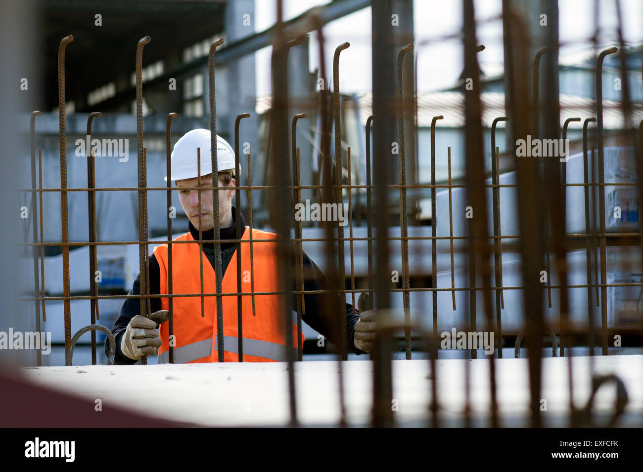 Factory worker choosing wire mesh in concrete reinforcement factory ...