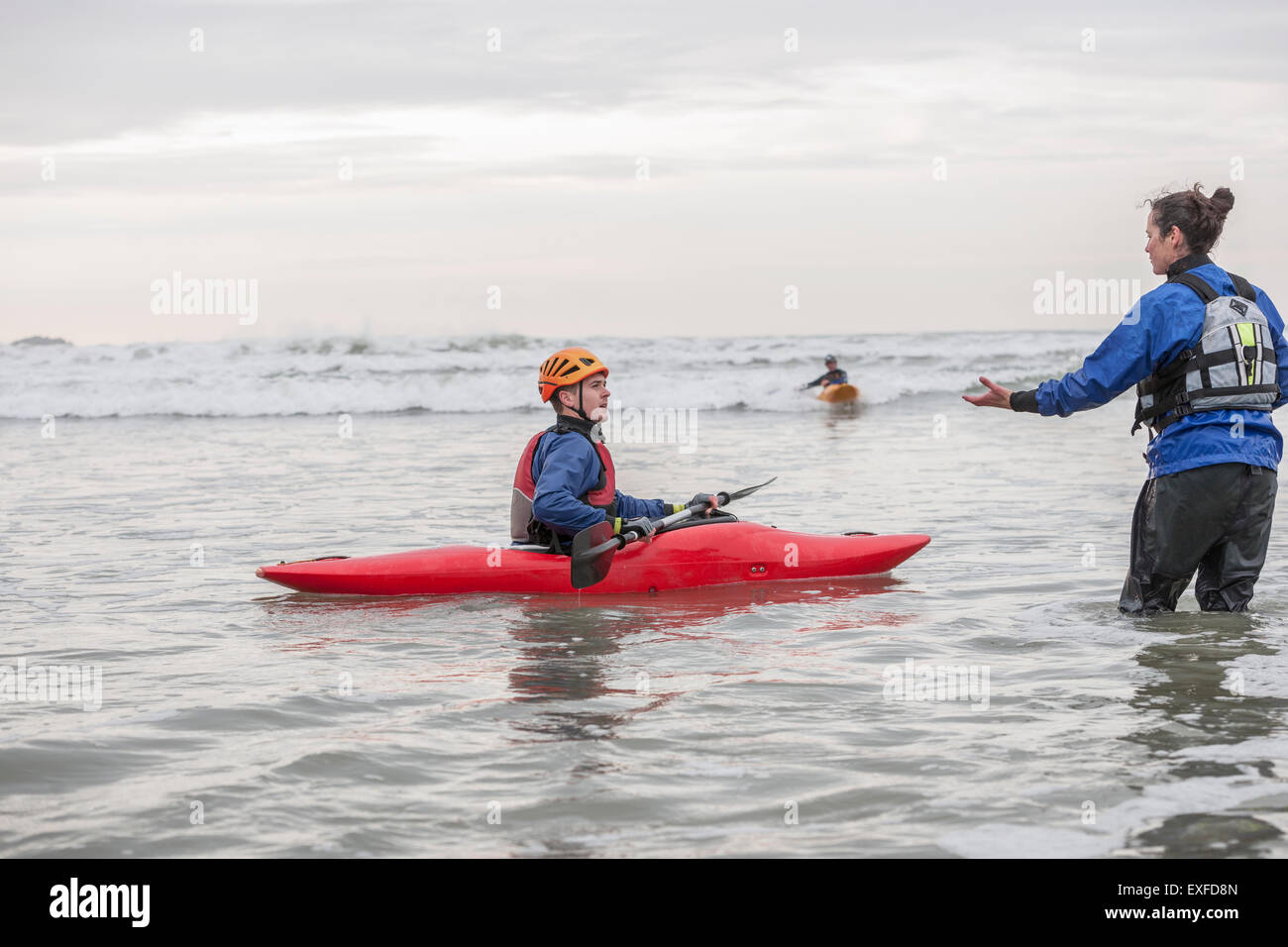 Female instructor helping young man in sea kayak Stock Photo - Alamy