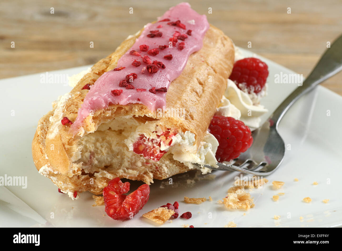 single cream filled eclair with fresh rapberries and raspberry icing ...