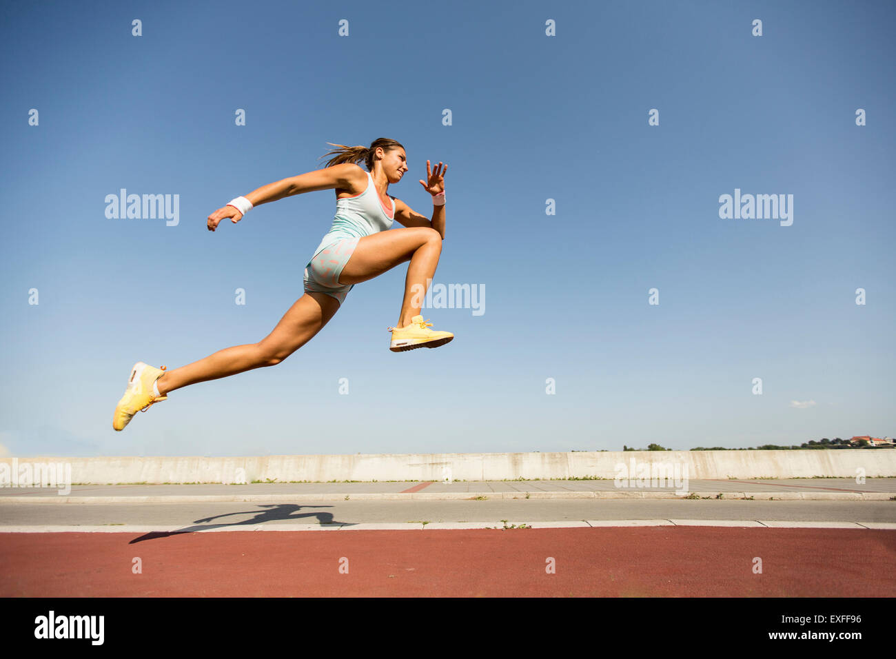 Young woman taking long jump Stock Photo - Alamy