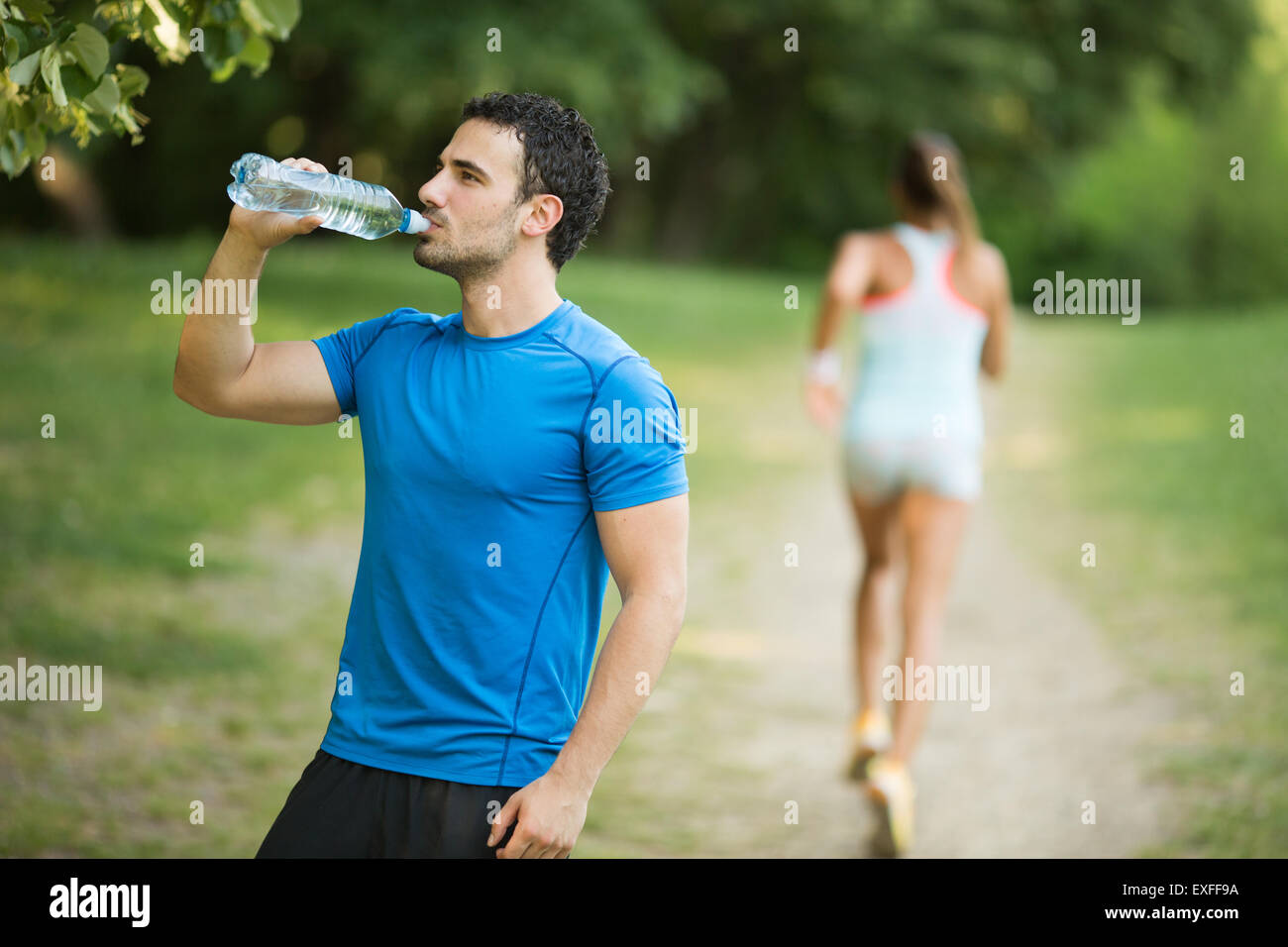 Young man drinking water outdoors Stock Photo - Alamy