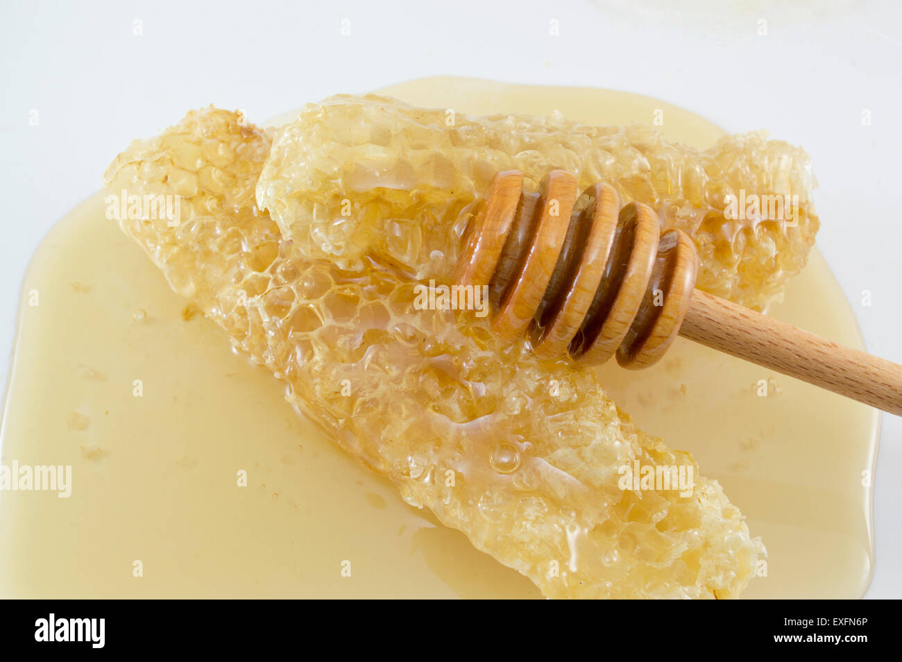 Honeycomb covered with honey and dipper spoon on white backgound Stock ...